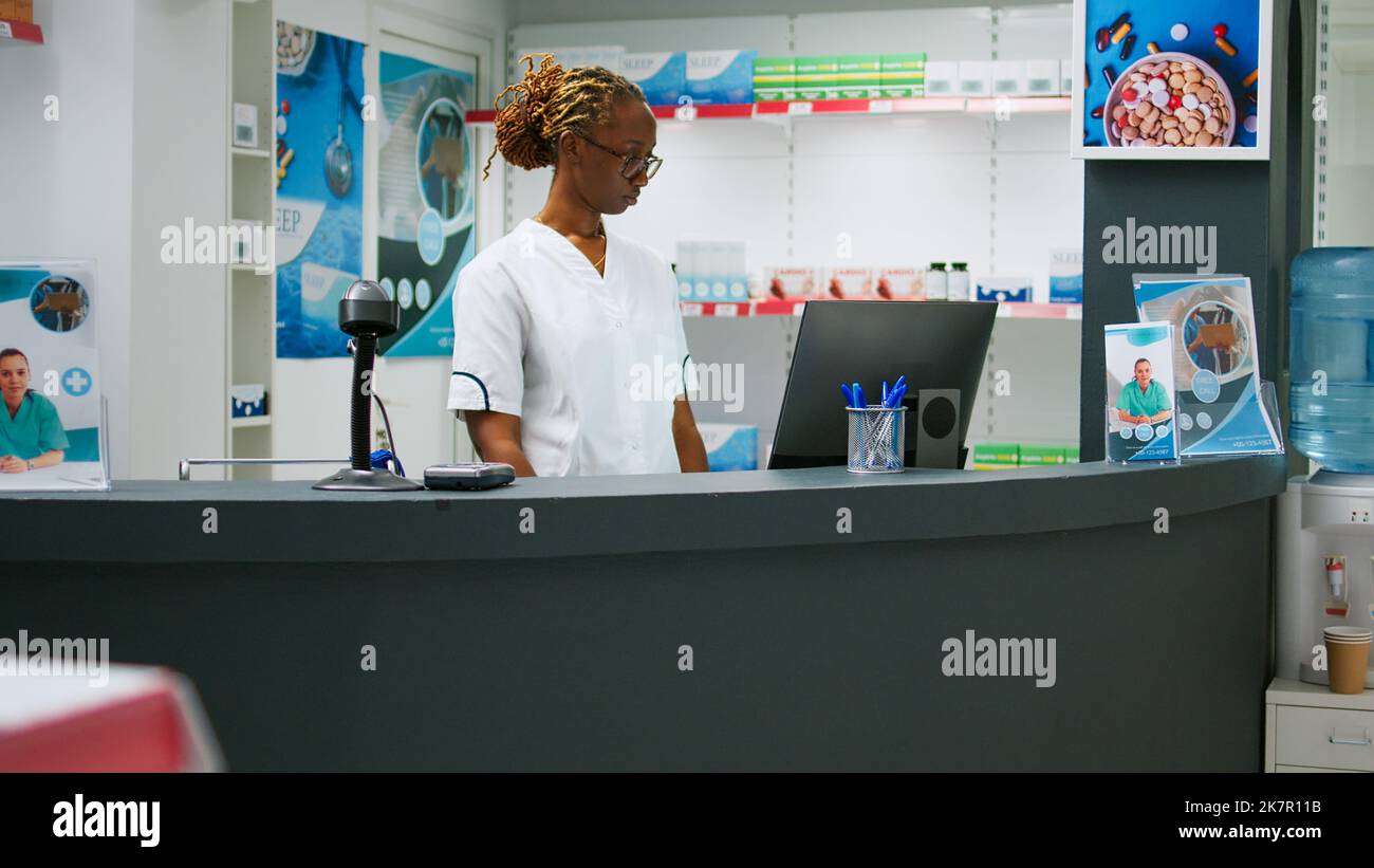 African american pharmacist working at drugstore with pharmaceutical ...