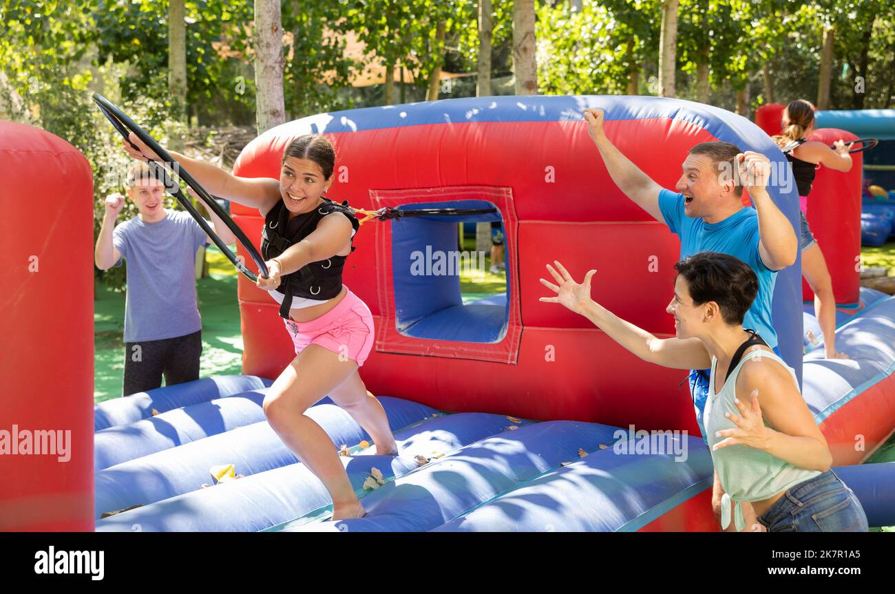 Girl playing tug of war game with hoop on playground in amusement park ...