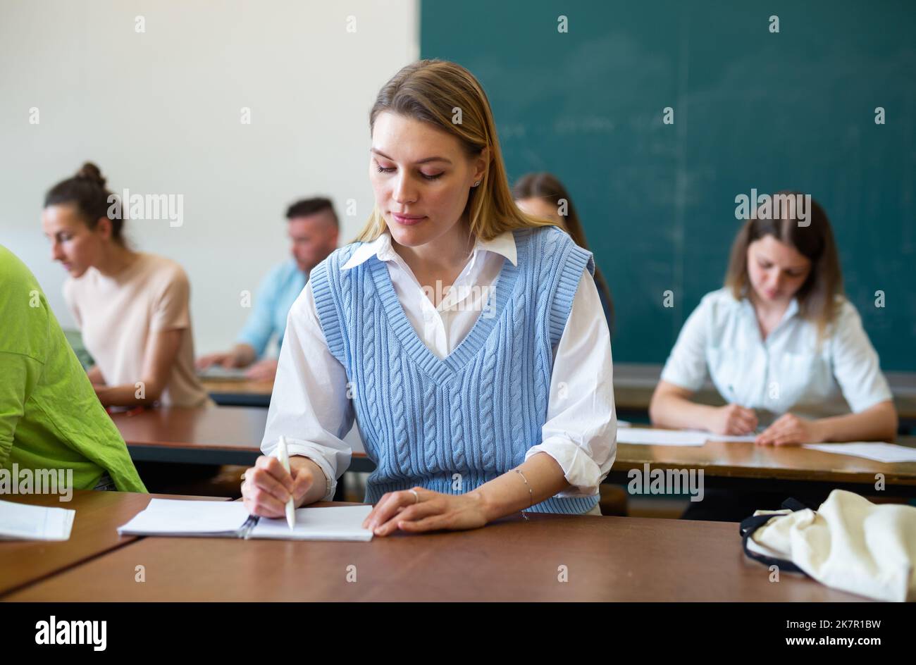 Woman university student writing in classroom Stock Photo - Alamy
