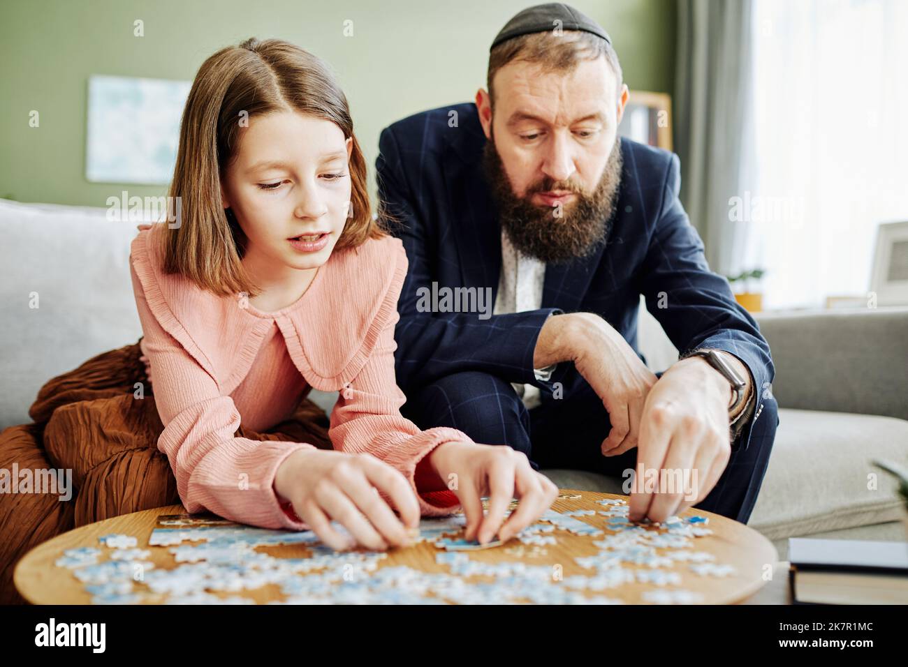 Portrait of orthodox jewish father playing puzzle game with young ...