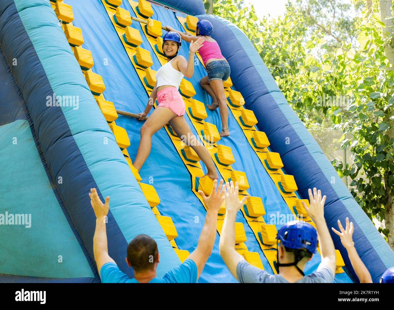 Women climbing up on slide in adventure park Stock Photo - Alamy
