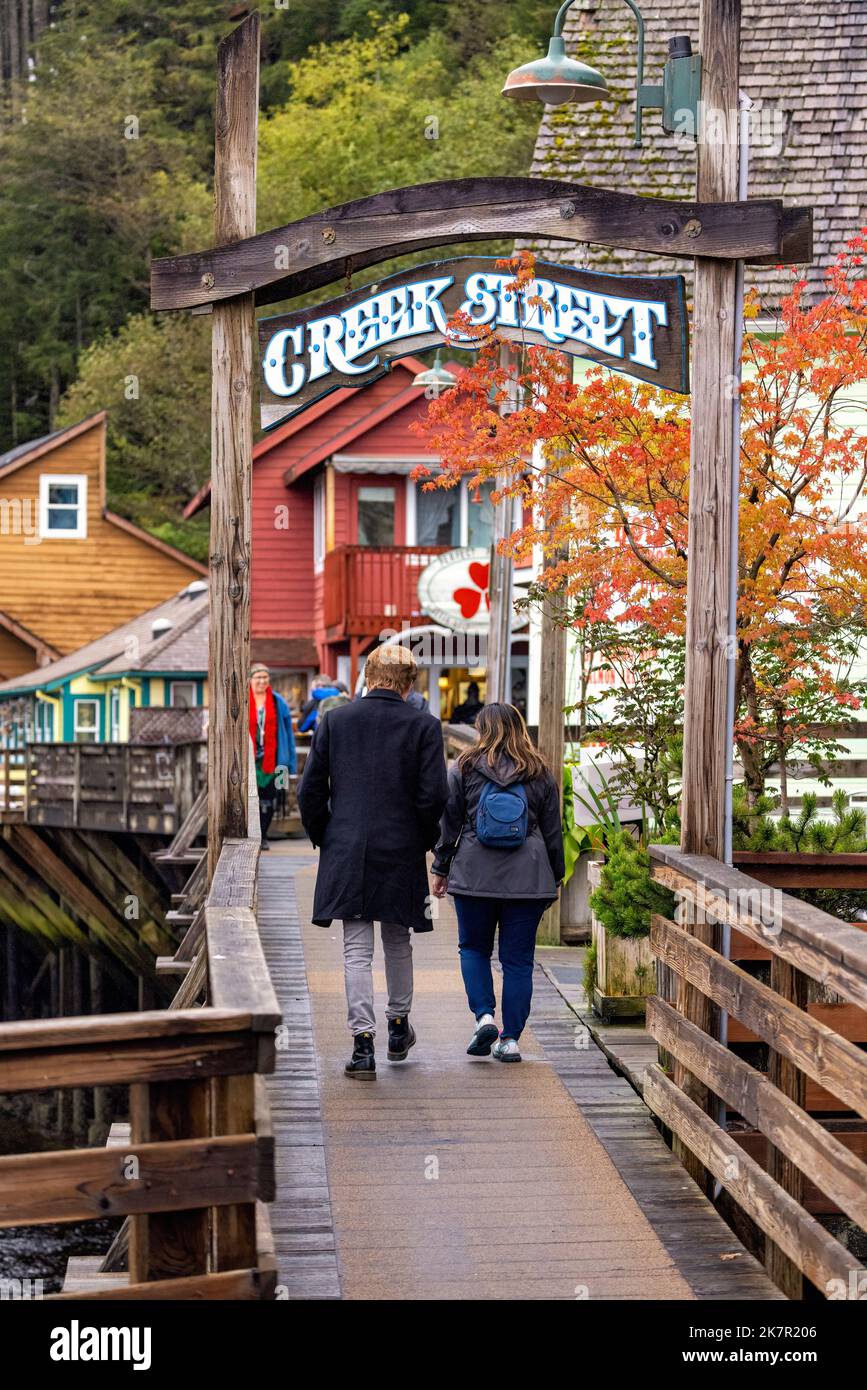 Couple walking down boardwalk on historic Creek Street in Ketchikan ...
