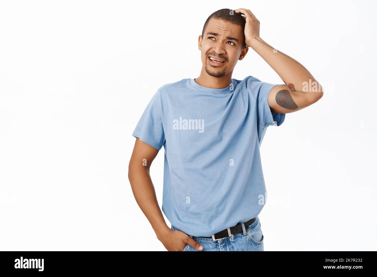 Confused guy scratching head and looking puzzled up, thinking, standing ...