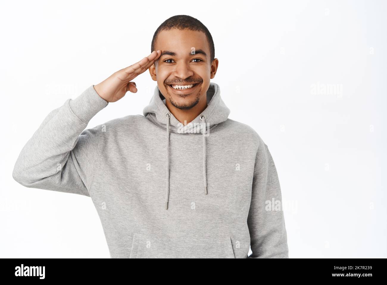 Image of young man saluting, holding hand near forehead, army greeting ...