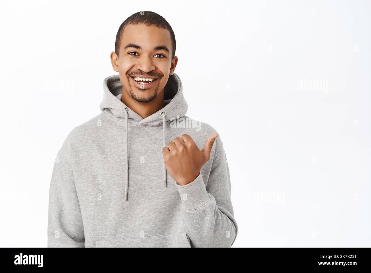 Handsome arab guy pointing right, smiling and showing direction, way to ...