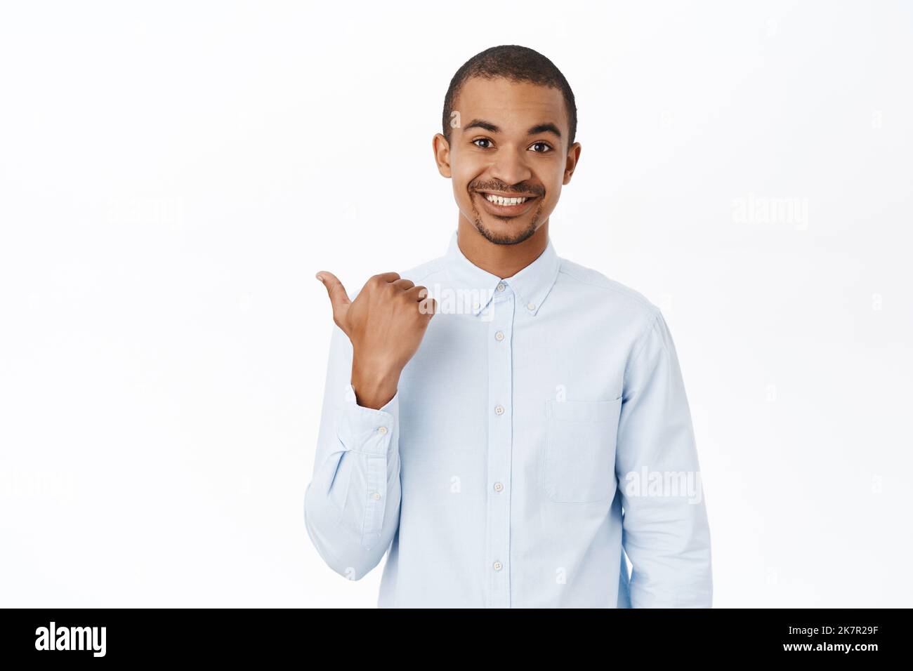 Smiling arab man pointing left, showing direction, company logo or ...