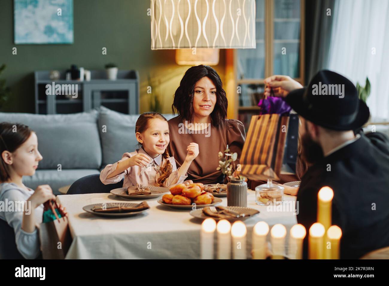 Portrait of modern jewish family enjoying dinner together at home and ...