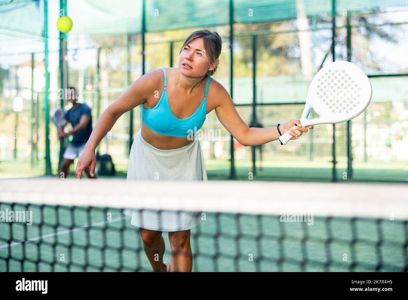 Young female paddle tennis player performing left-handed forehand Stock ...