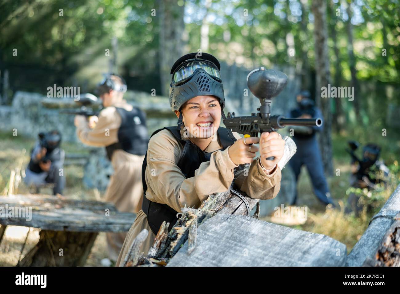 Happy girl targeting shooting with paintball marker Stock Photo - Alamy