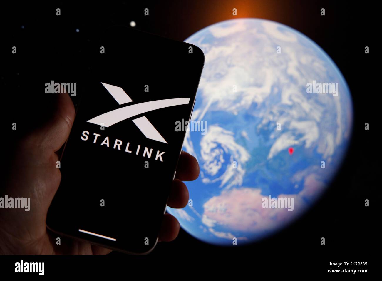 The Starlink logo is seen on a mobile device with an grahpic ...