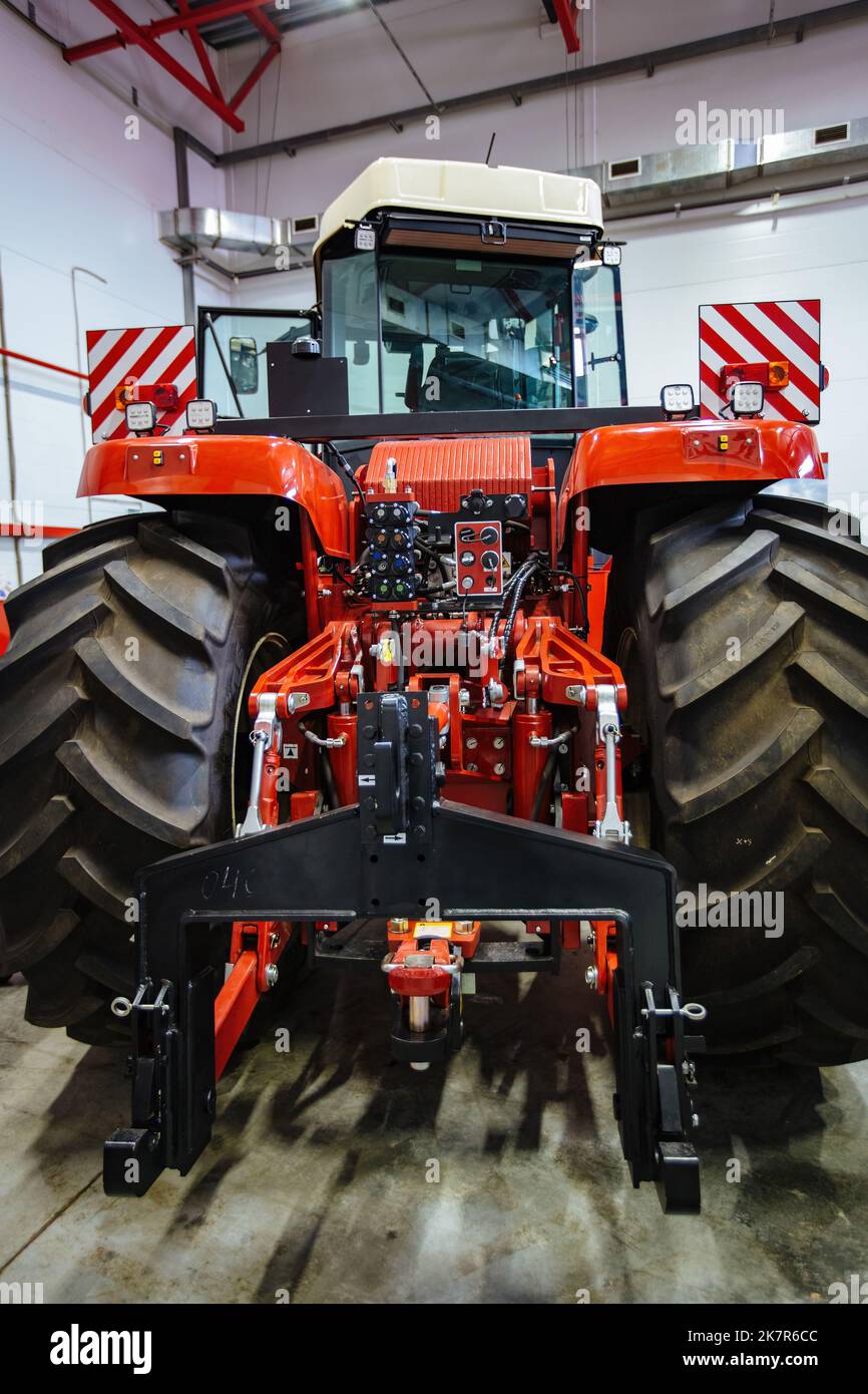 Rear view of modern agricultural tractor in hangar. Hydraulic hitch ...