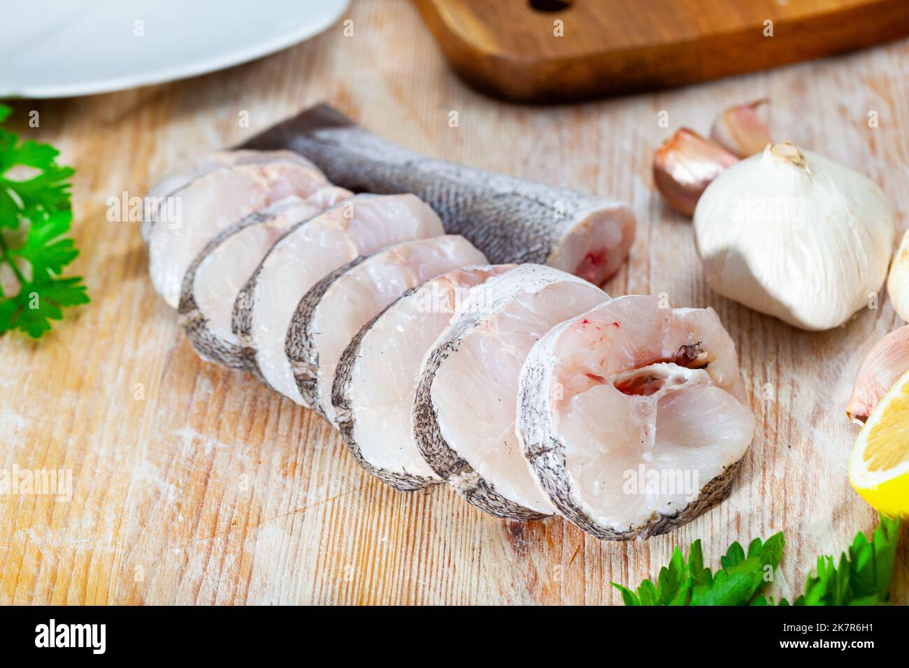 Raw steaks of hake with lemon and greens ready for cooking Stock Photo ...