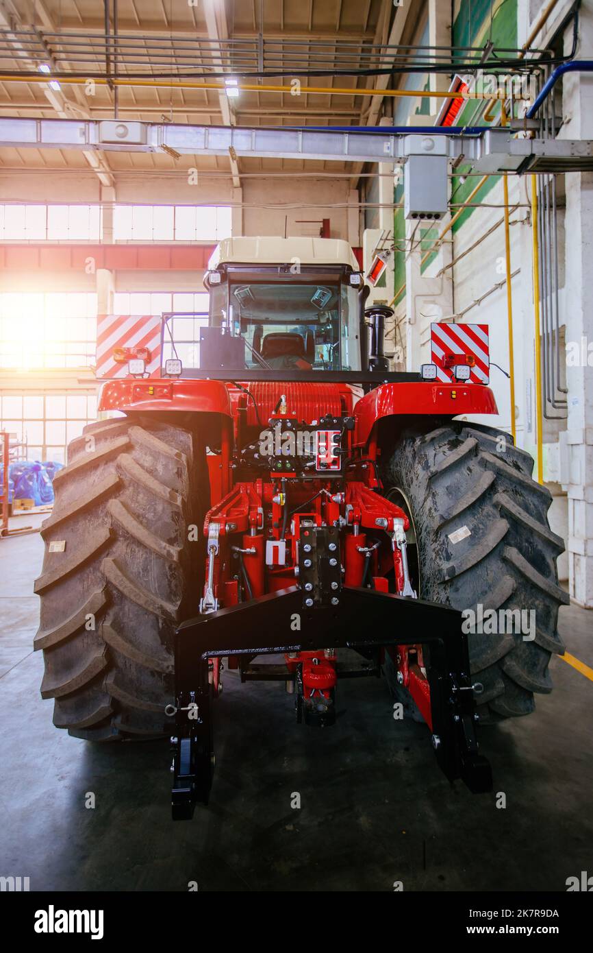 Rear view of modern agricultural tractor in hangar. Hydraulic hitch ...