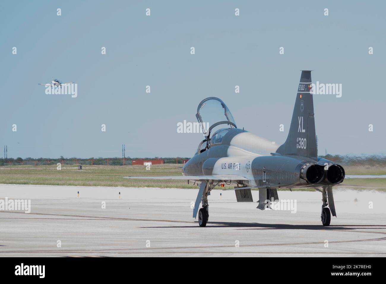 A T-6A Texan II (left) begins a descent to land as a T-38C Talon taxis ...