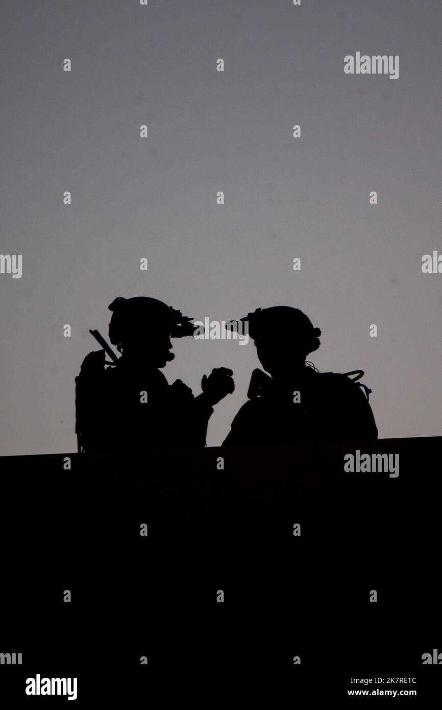 U.S. Navy Seals communicate with one another on a rooftop during ...