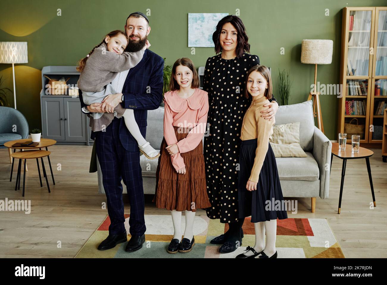 Full length portrait of happy jewish family standing in modern home and ...