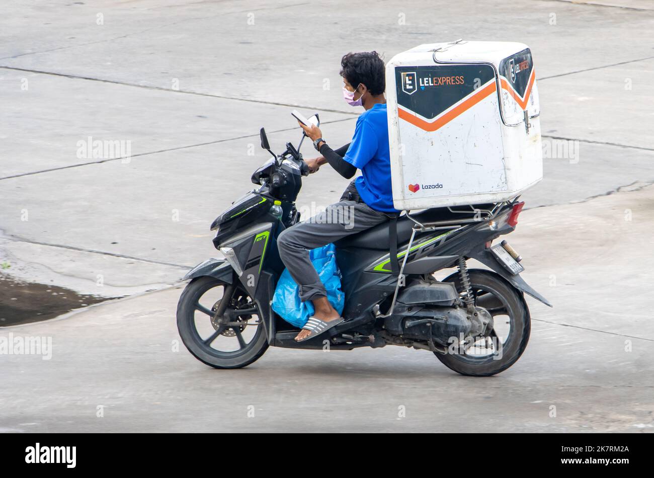 SAMUT PRAKAN, THAILAND, SEP 23 2022, A delivery worker rides a ...
