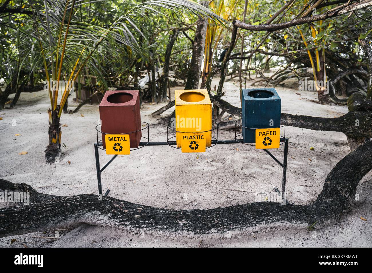 Three trash containers for separate waste collection raised above the ...