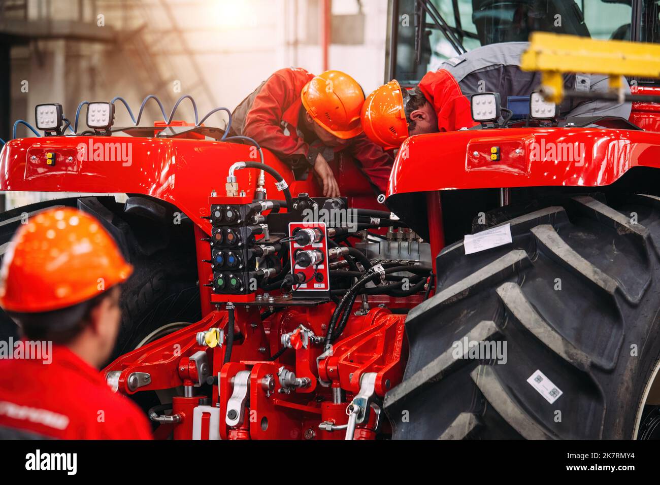 Industrial workers assembles agricultural tractor in workshop Stock ...