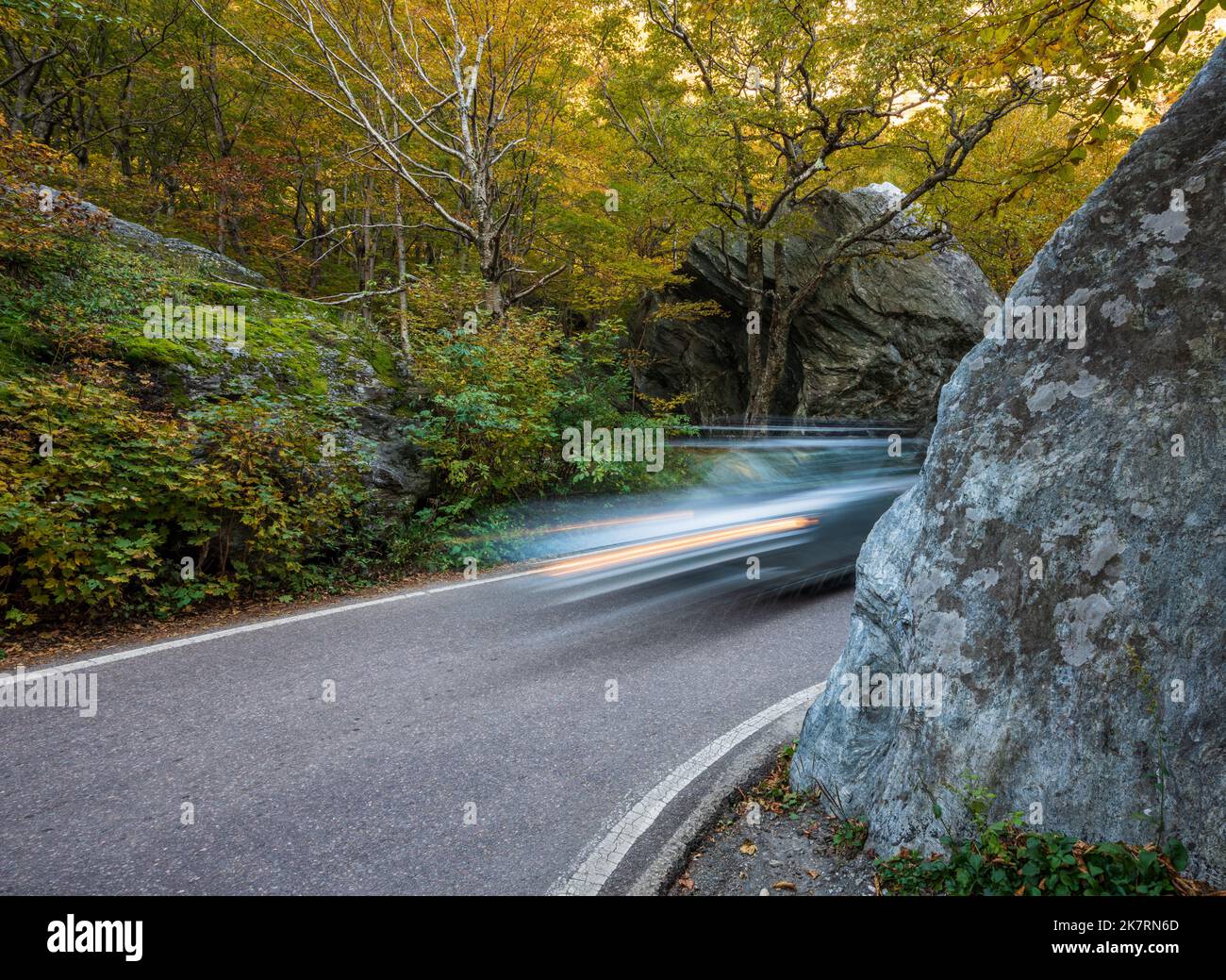 Car takes narrow bend between boulders in Smugglers Notch in the fall ...