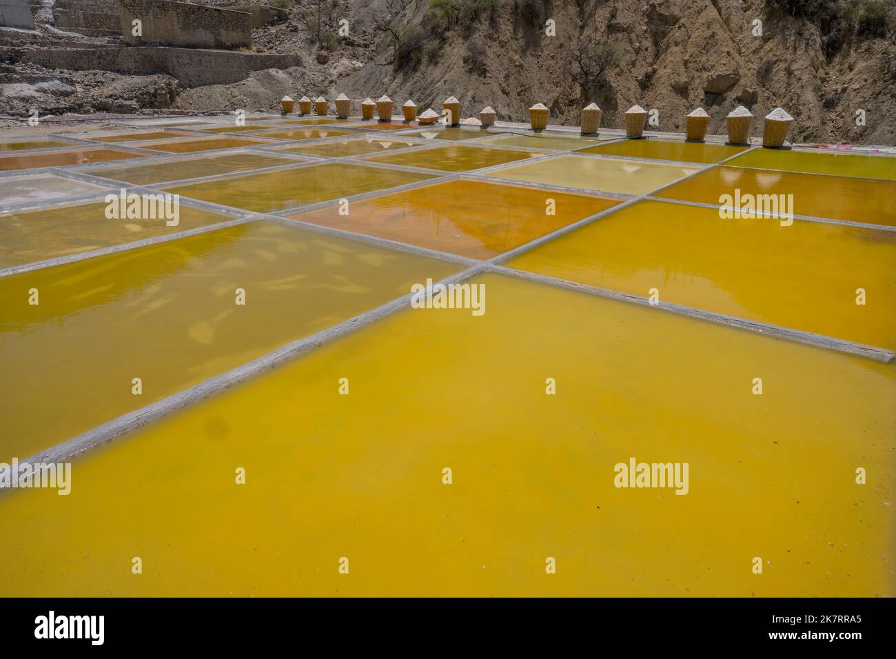 View of the saline pools and baskets of drying salt at a salt mining ...