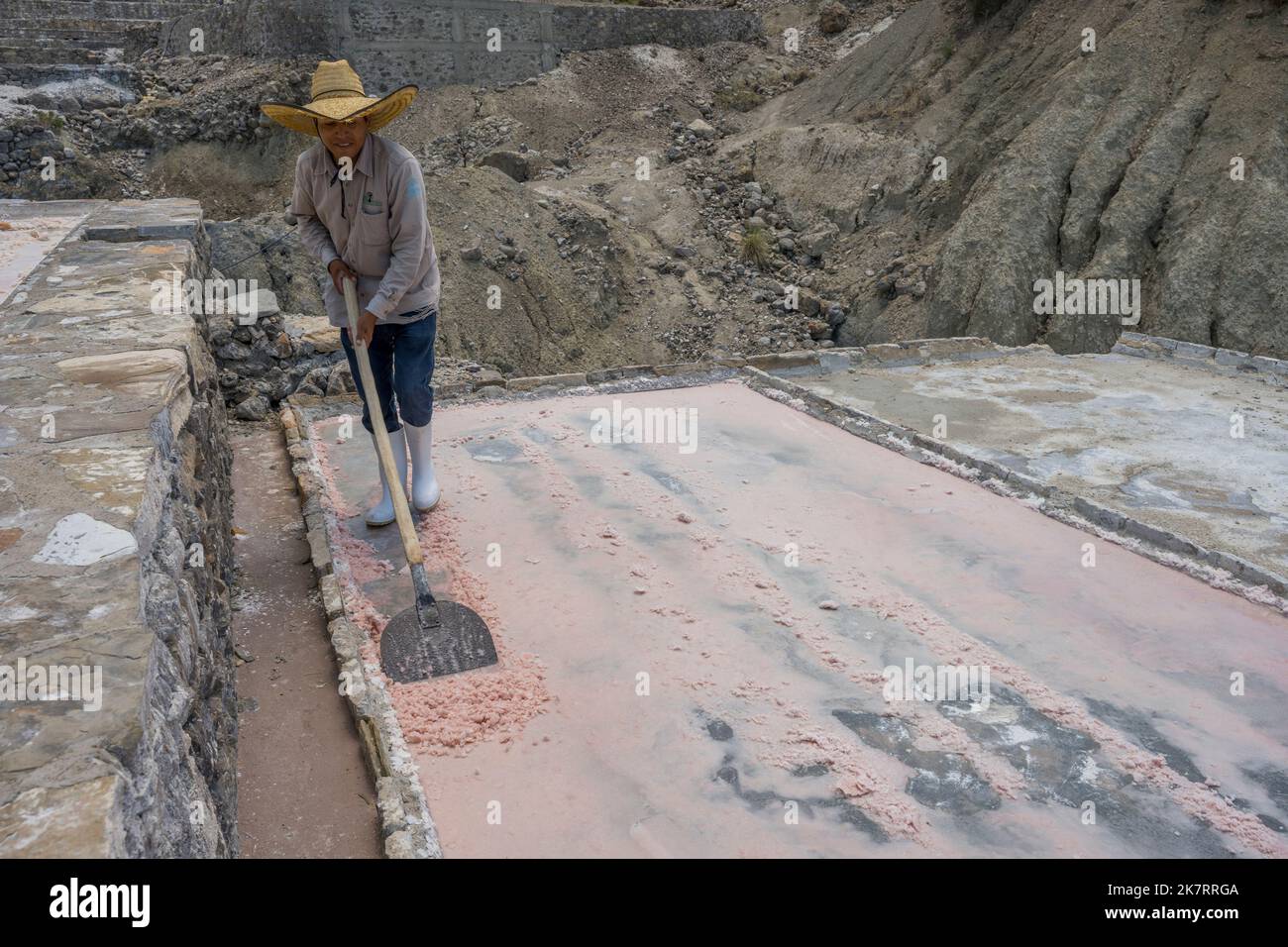 A man is working in the saline pools at a salt mining operation in ...
