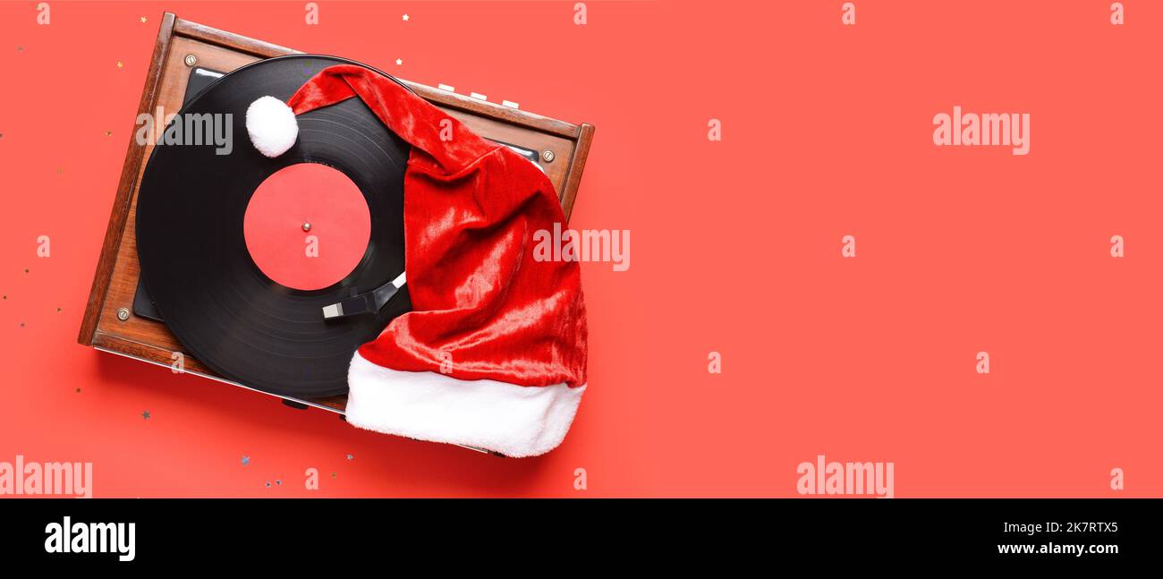 Record player and Santa hat on red background with space for text Stock ...