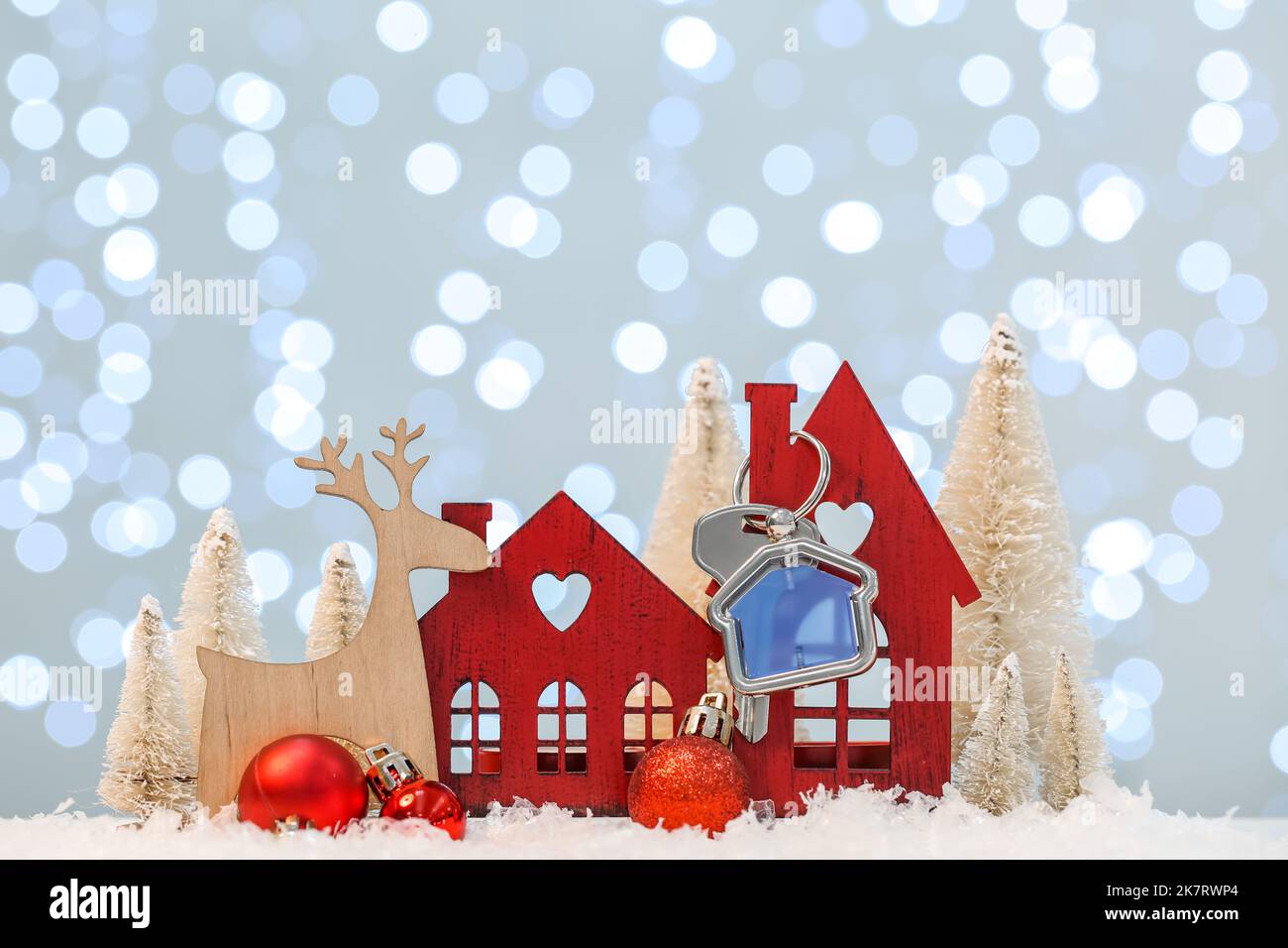 House figures with key and Christmas decor on table against blurred ...