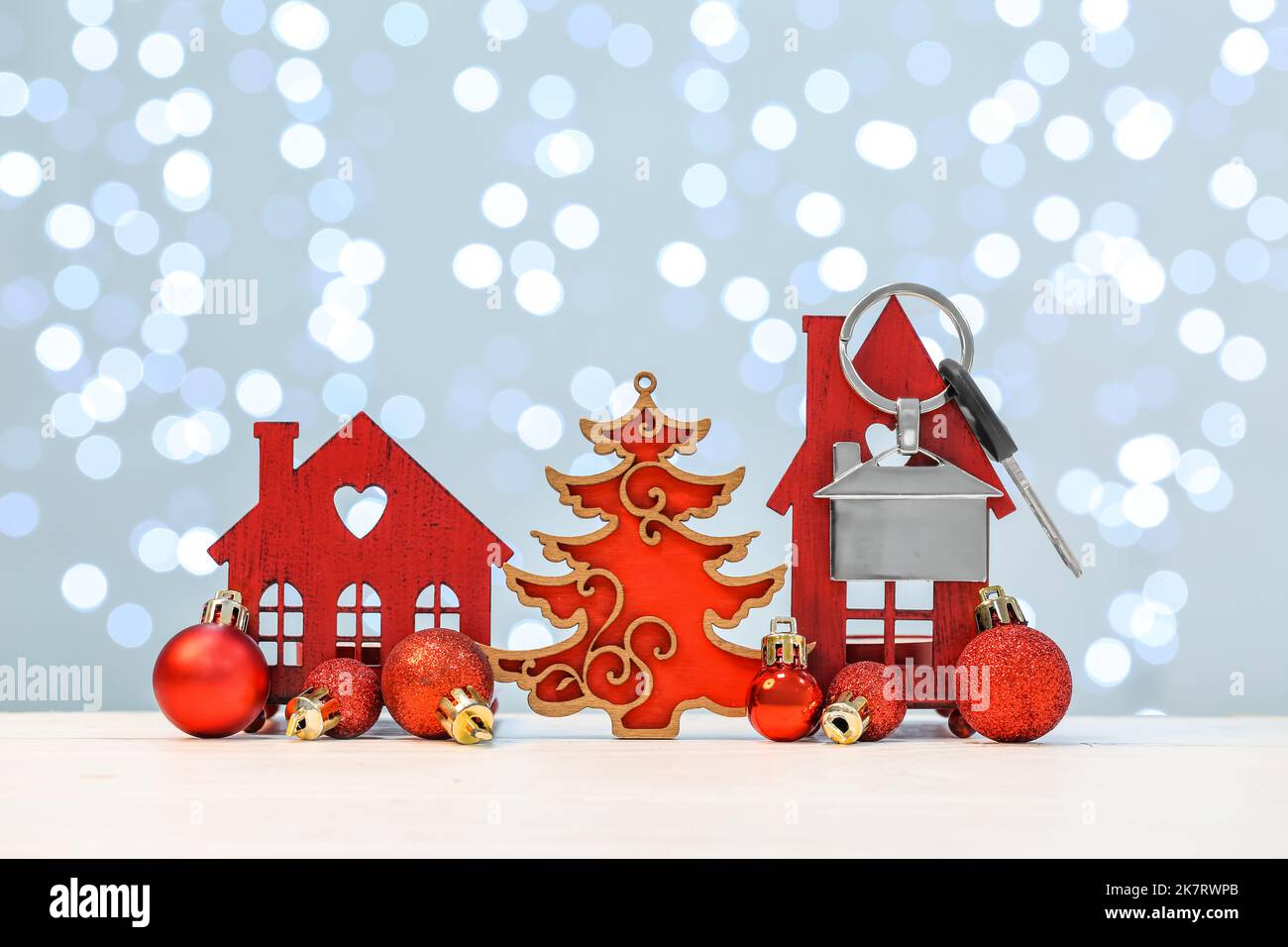 House figures with key and Christmas decor on table against blurred ...