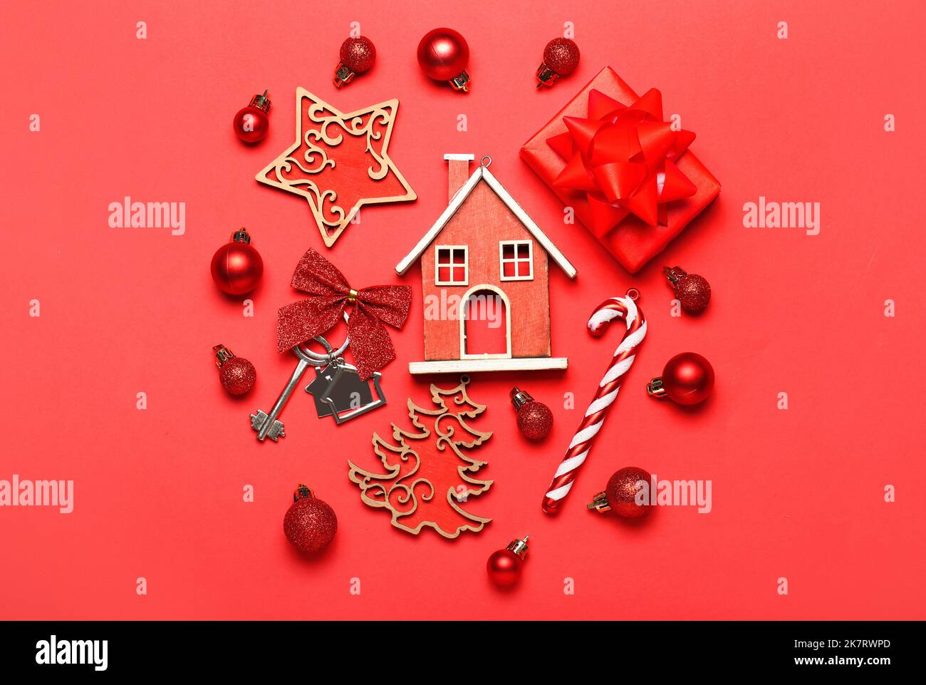 House figure with key and Christmas decor on red background Stock Photo ...