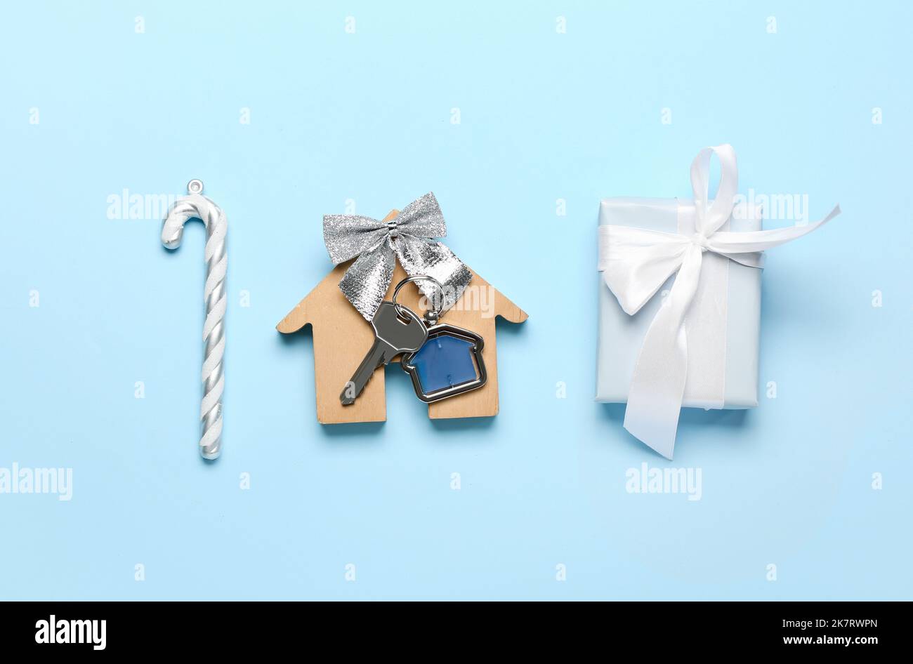 House figure with key, Christmas gift and candy cane on blue background ...