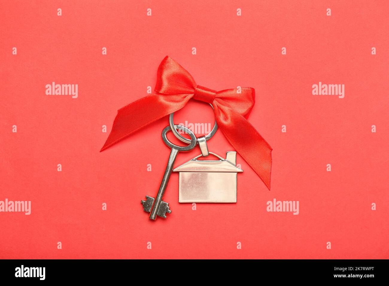 Key from new house with bow on red background Stock Photo - Alamy