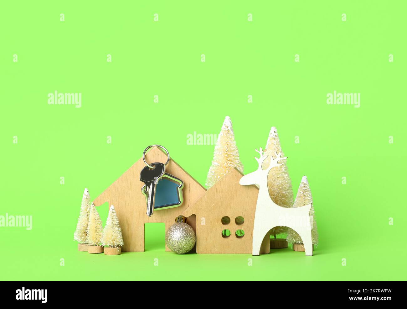 House figures with key and Christmas decor on green background Stock ...