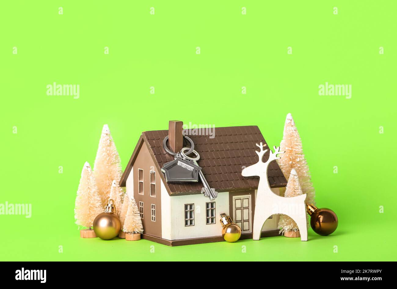 House model with key and Christmas decor on green background Stock ...