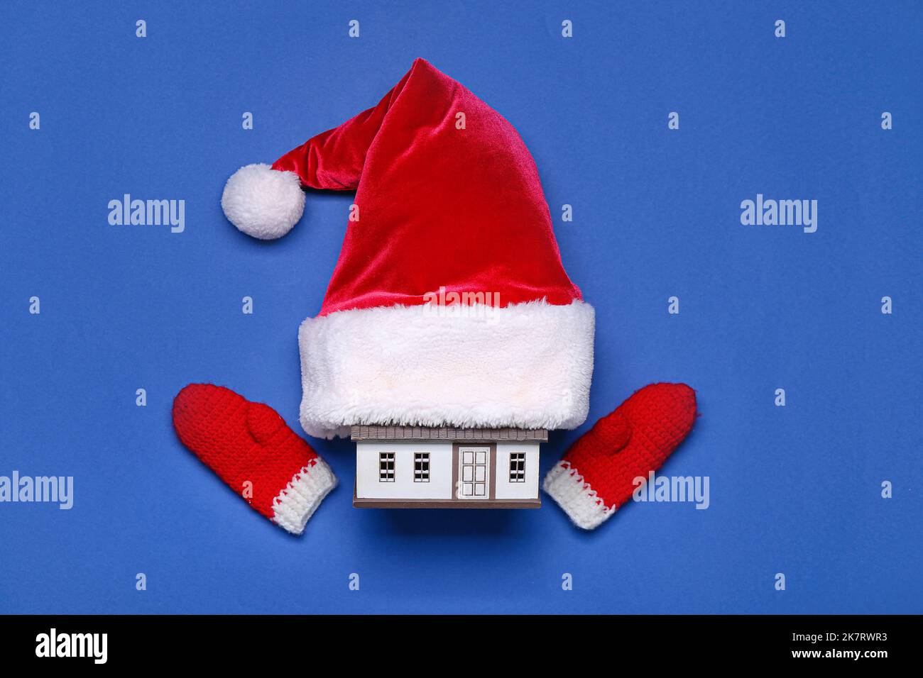 House model with Santa hat and mittens on blue background Stock Photo ...