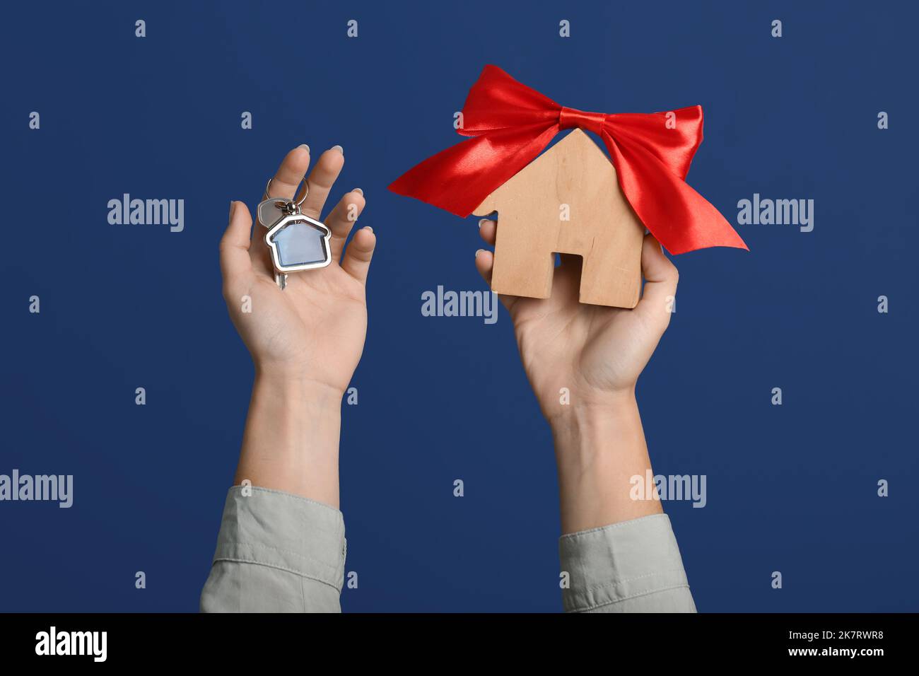 Real estate agent with house figure and key on blue background Stock ...