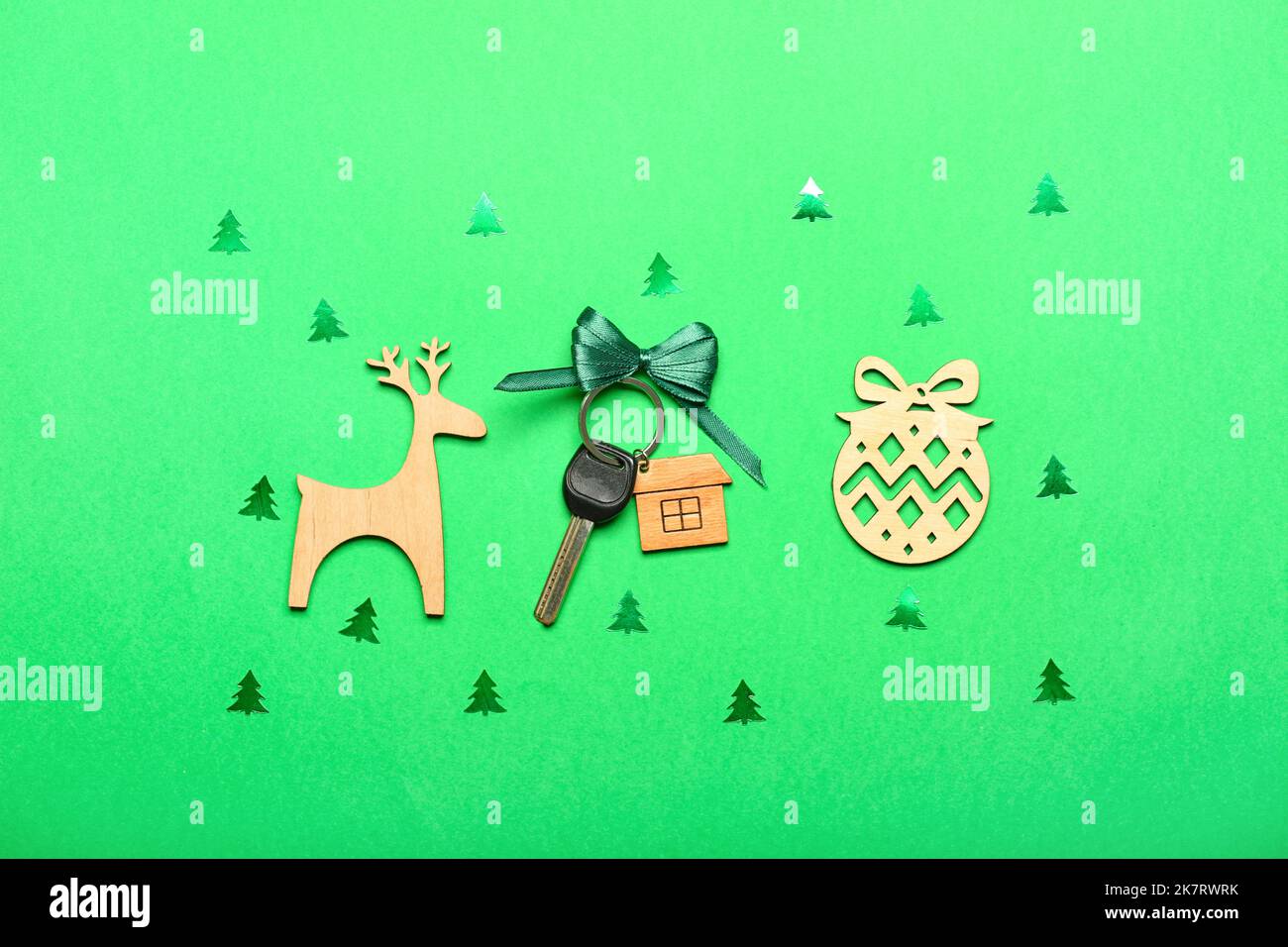 Key from new house with bow and Christmas decor on green background ...