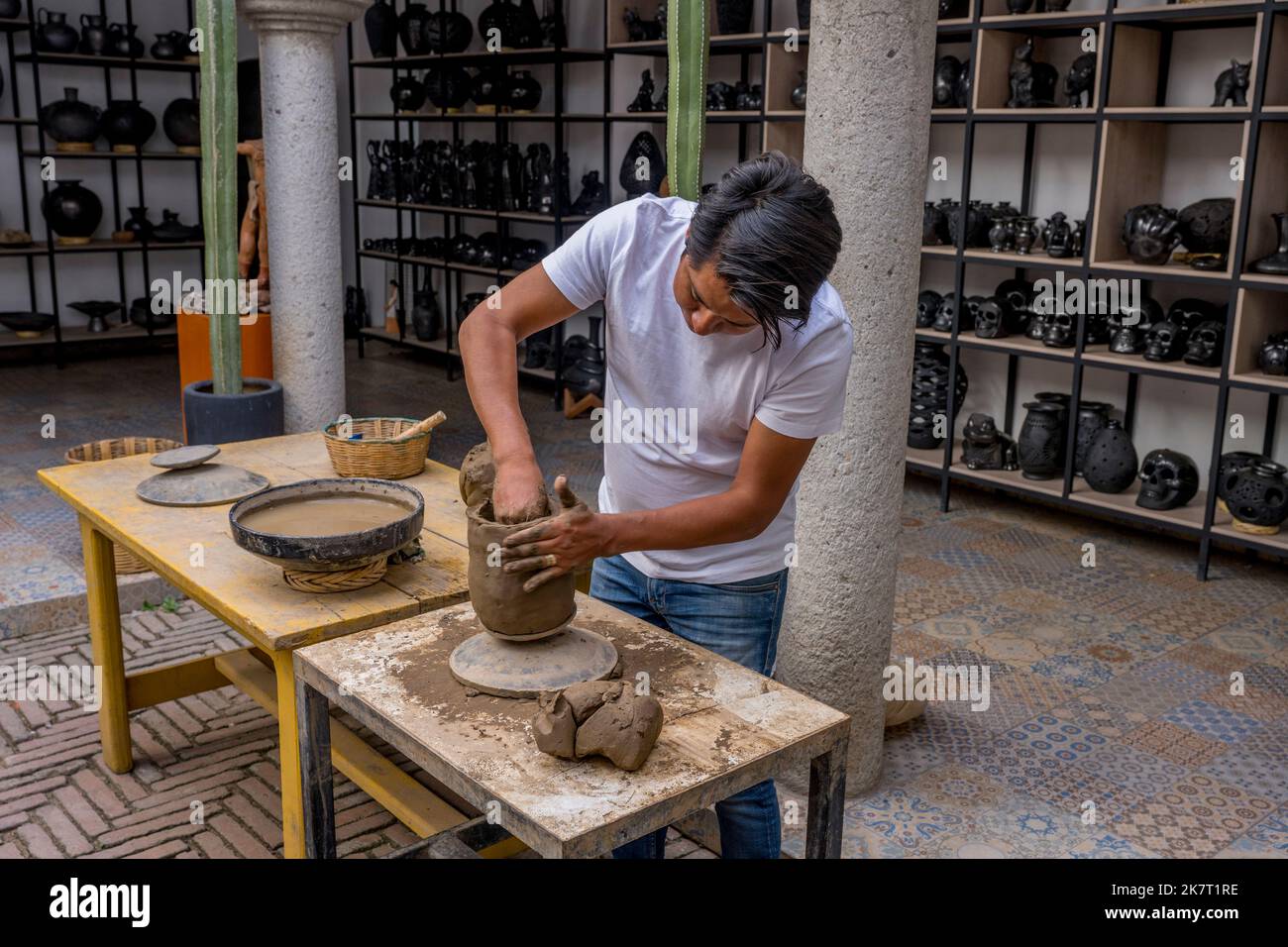 A potter is making a Barro negro pottery (black clay pottery) vase ...