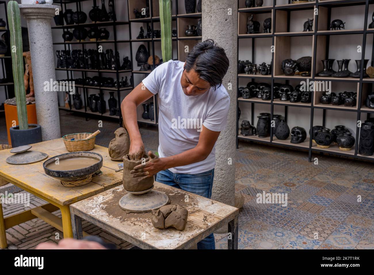 A potter is making a Barro negro pottery (black clay pottery) vase ...