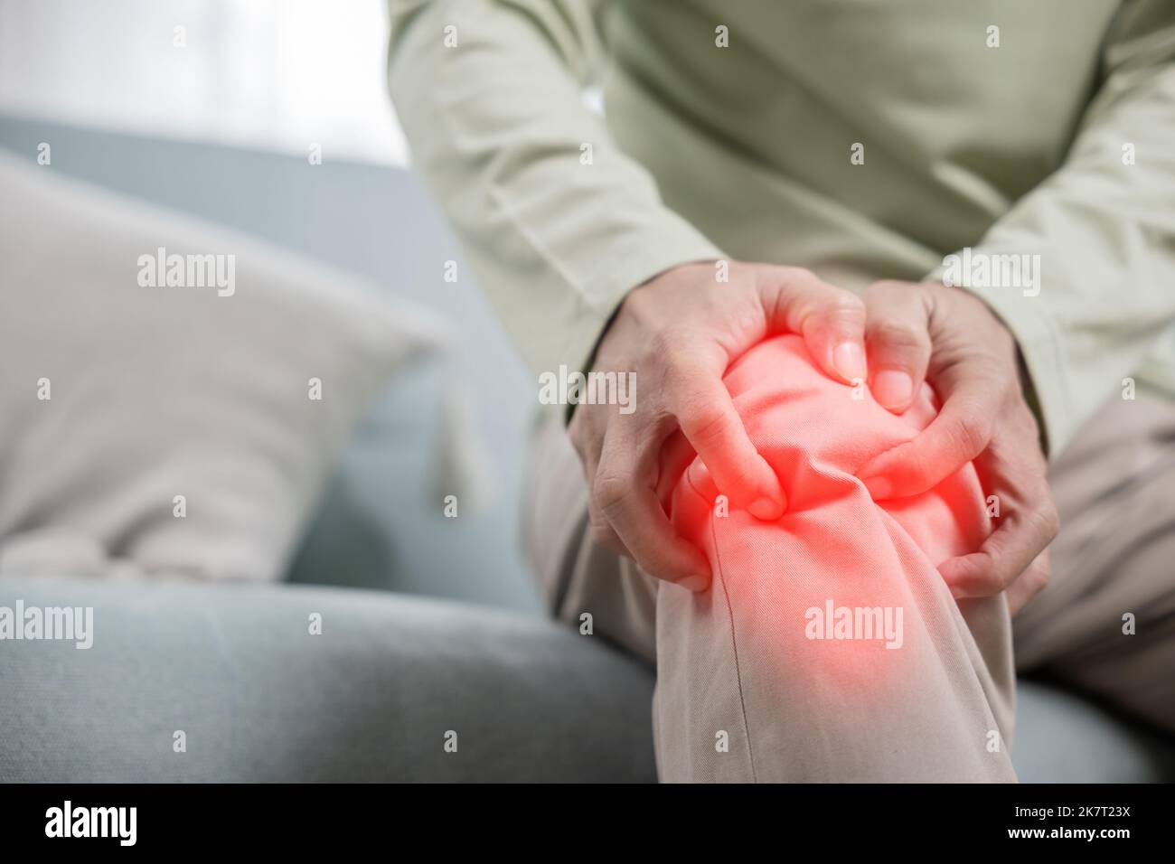 Old man suffering from knee joint pain on sofa living room, bone pain ...
