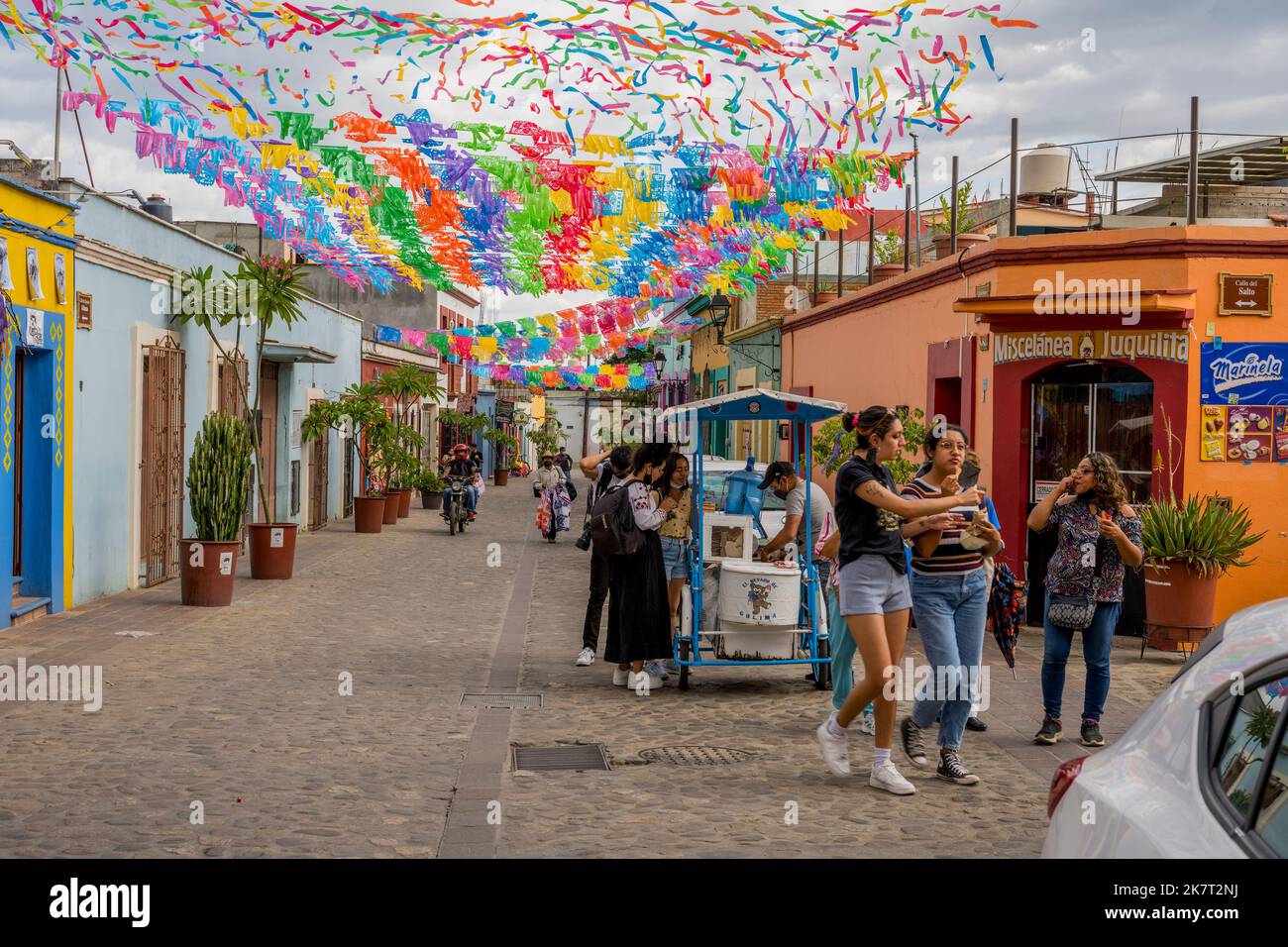 People getting ice cream from a street vendor in the with Papel picado ...