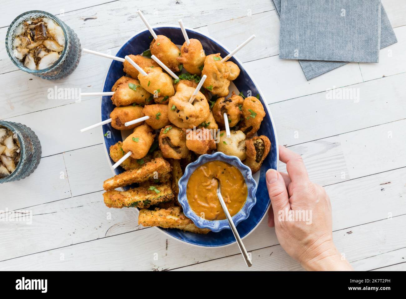 A hand serving a platter of deep fried appetizers, for sharing Stock ...