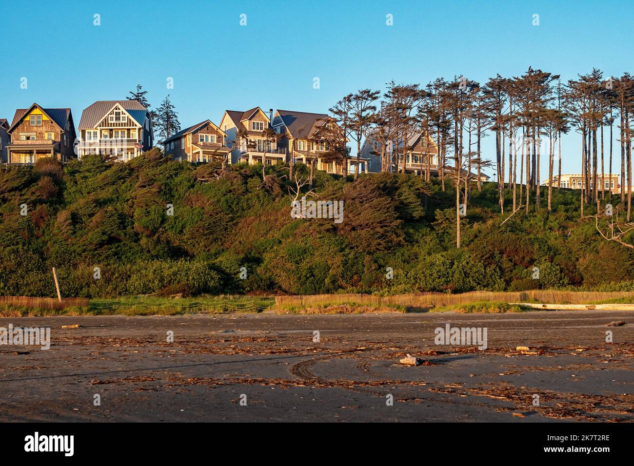 Large houses sit atop a cliff in the evening light, surrounded by ...