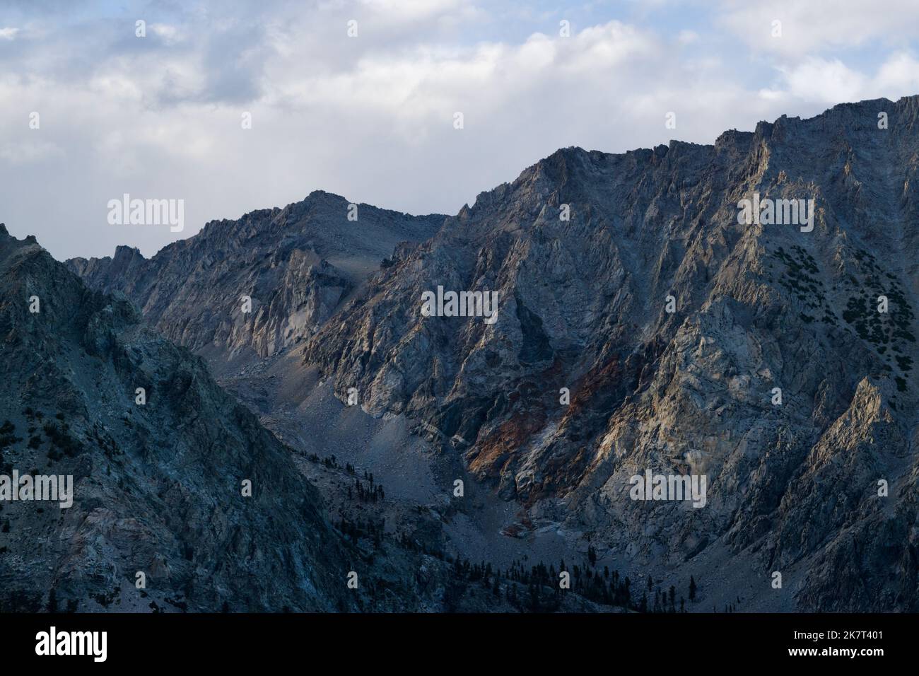 Detail view of a dramatic granite mountain face partially illuminated ...