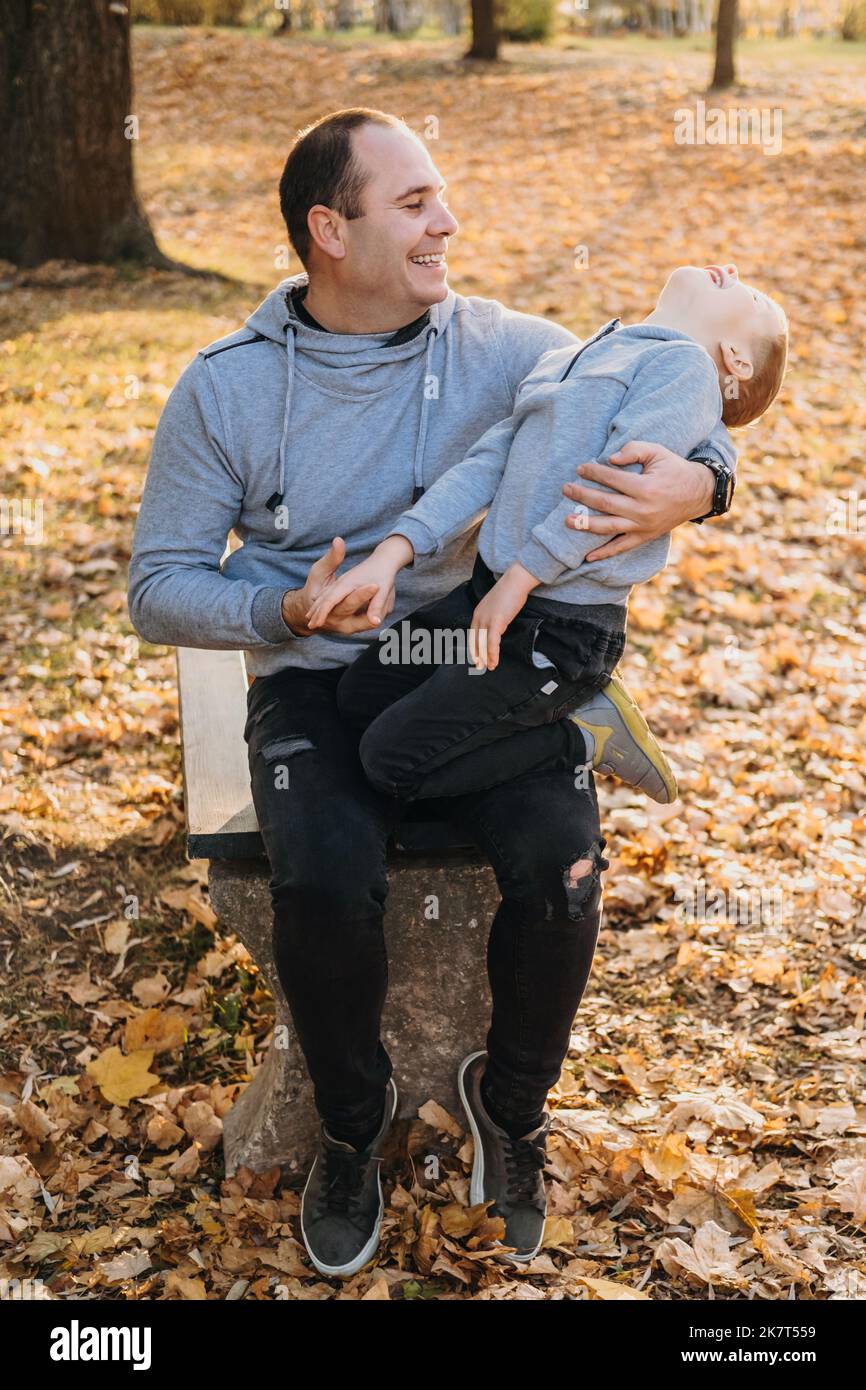 Caucasian father holding his son in arms while having fun in the ...