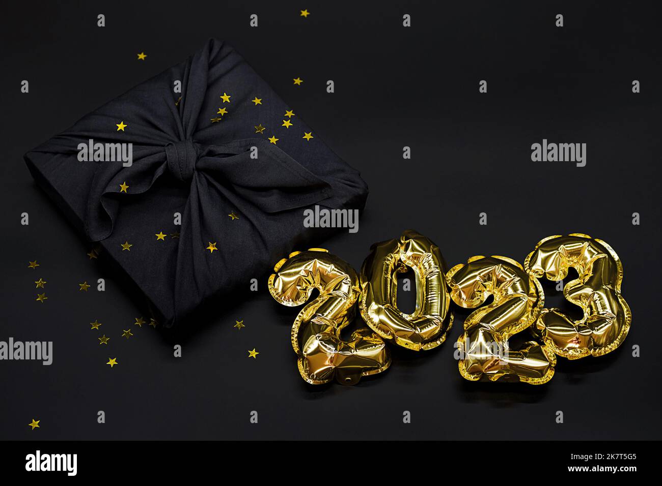 Gift box wrapped in fabric with 2023 numbers made from golden foil ...