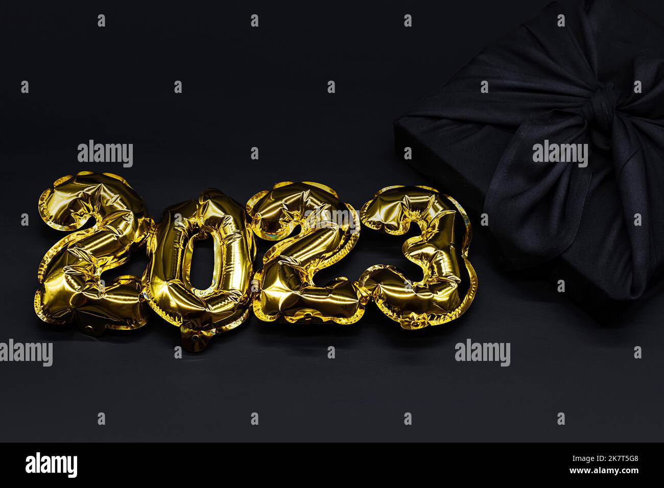 Gift box wrapped in fabric with 2023 numbers made from golden foil ...