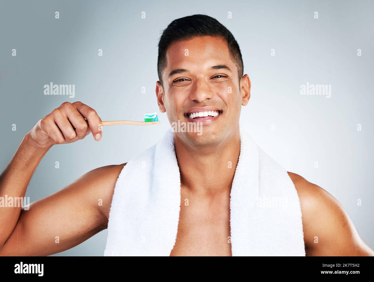 Mouth, dental and man brushing teeth in studio for hygiene, wellness and grooming against a grey ...