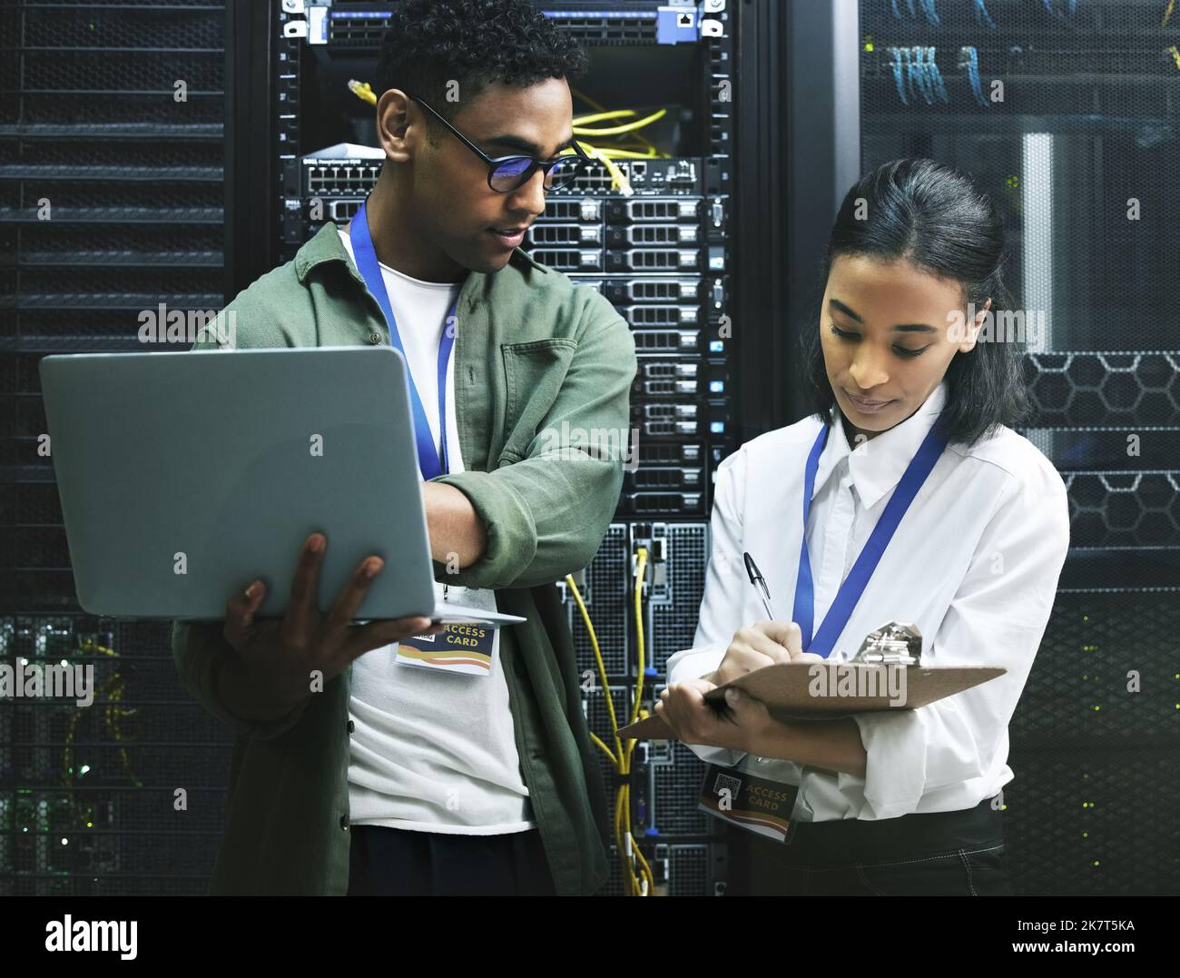 Make a note of this. two technicians working together in a server room ...