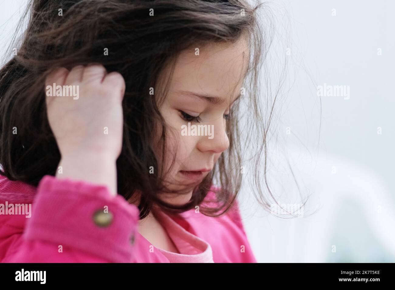 Pretty young girl is fiddling with small objects in the backyard Stock ...